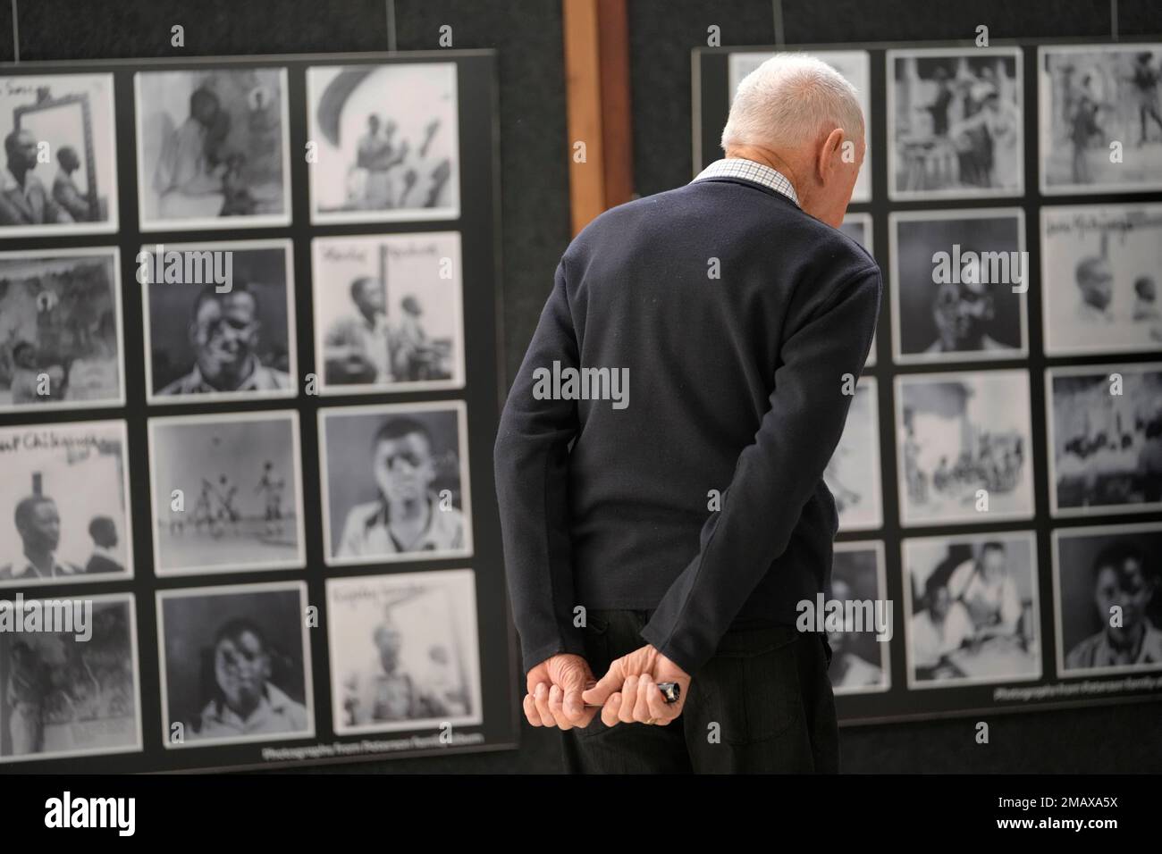 An elderly man walks past photographs of young Black students at Cyrene ...