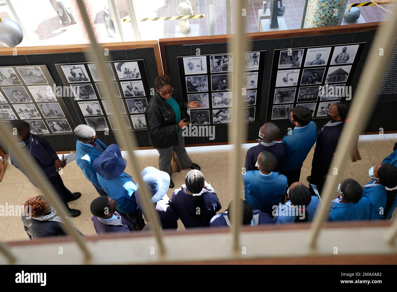 Schoolchildren look at photographs of young Black students at Cyrene ...