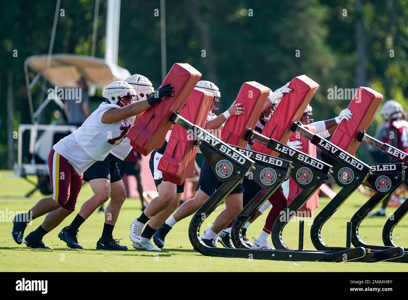 The Washington Commanders' offensive line runs a drill during practice ...