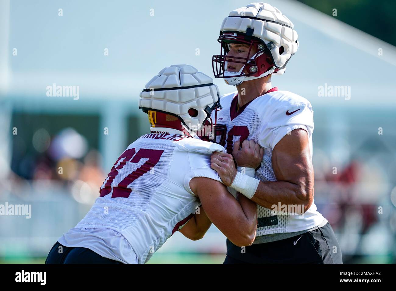 Washington Commanders tight end John Bates, left, works against tight ...