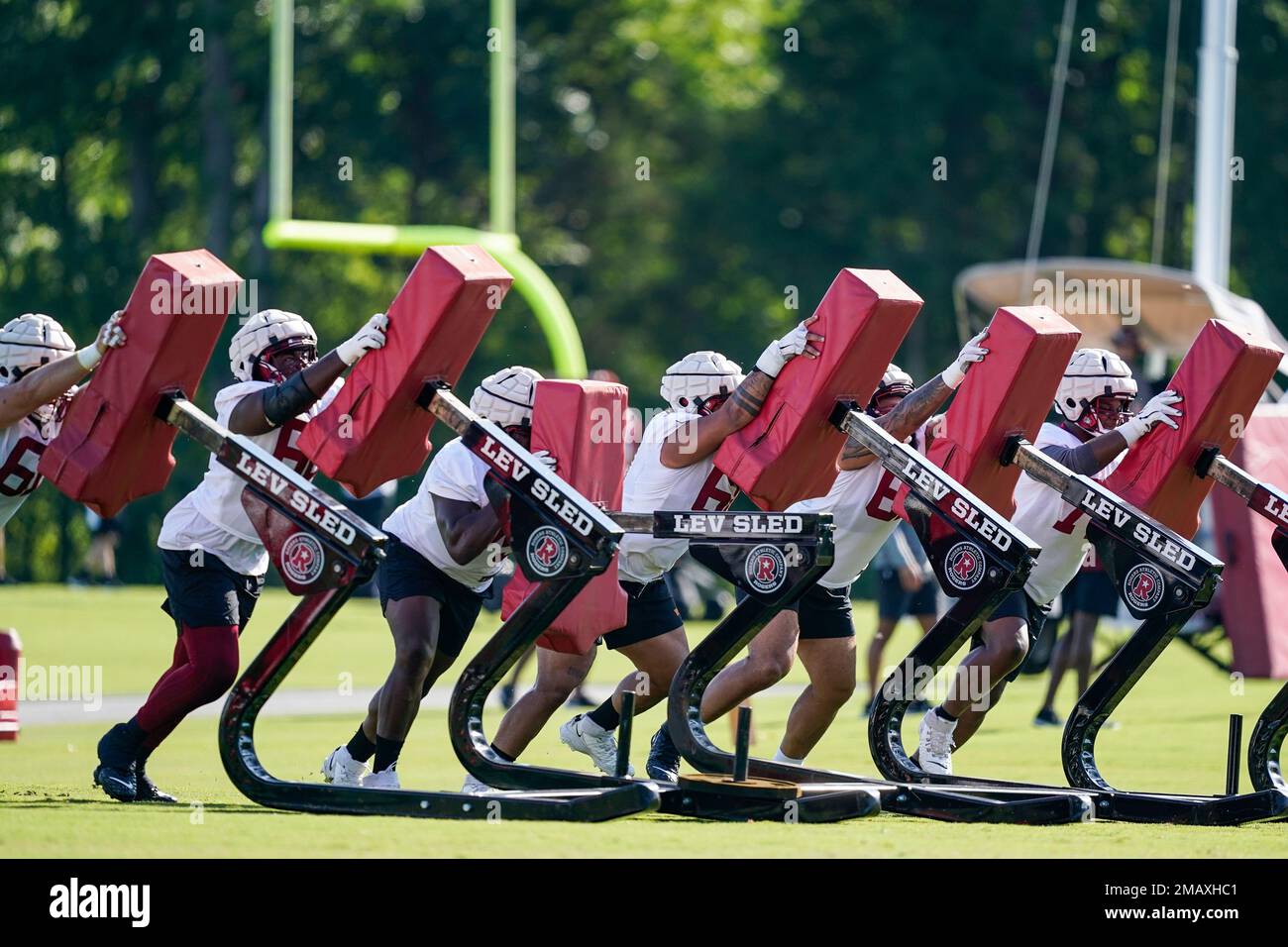 The Washington Commanders' offensive line runs a drill during practice ...