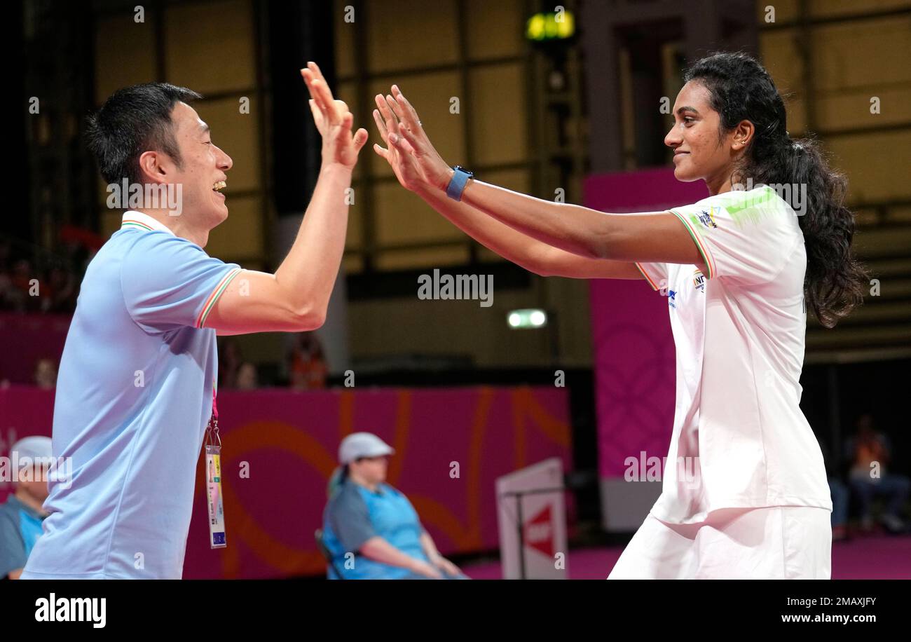 India's Venkata Sindhu Pusarla, right, celebrates with a coach Tae Sang ...