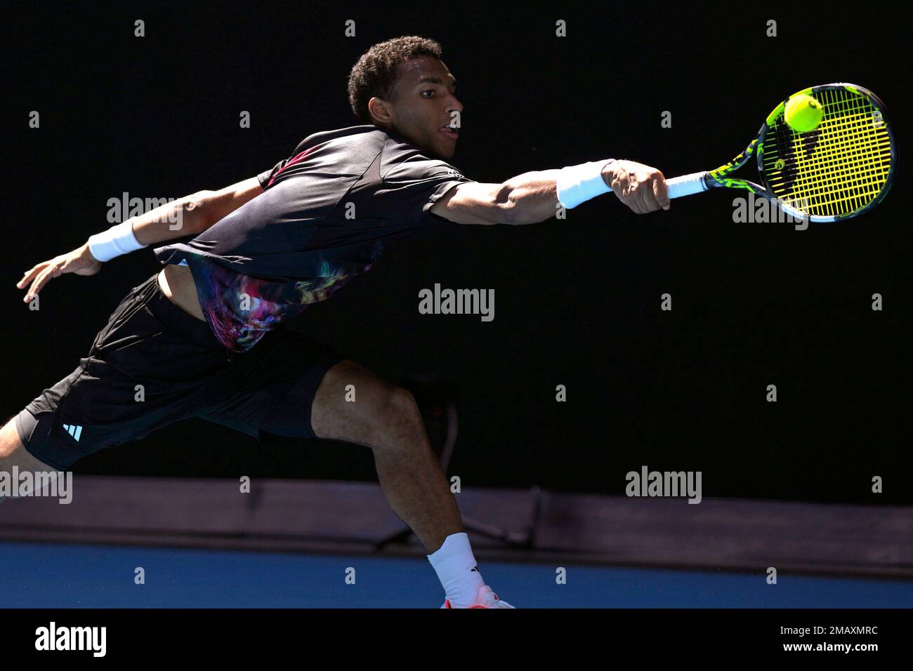 Felix Auger-Aliassime of Canada plays a backhand return to Francisco Cerundolo of Argentina ...