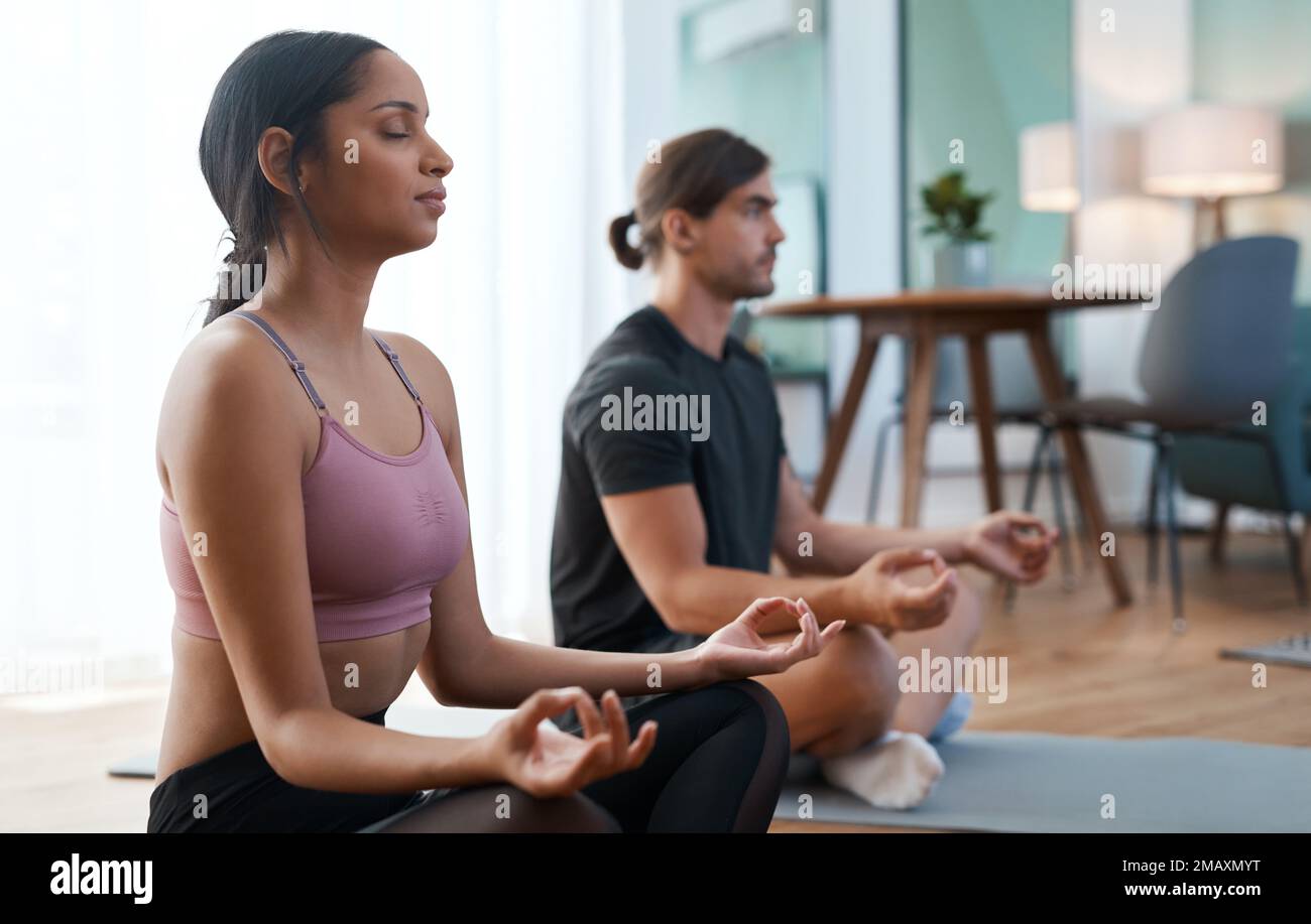 Calming their minds. an athletic young couple meditating during their ...
