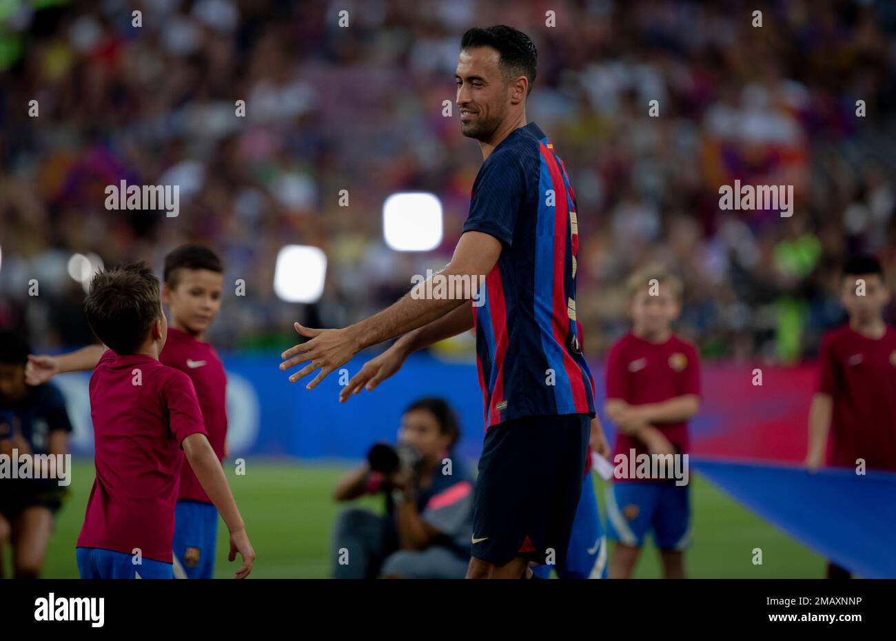 Barcelona's Sergio Busquets waves the kids before the start of the Joan ...