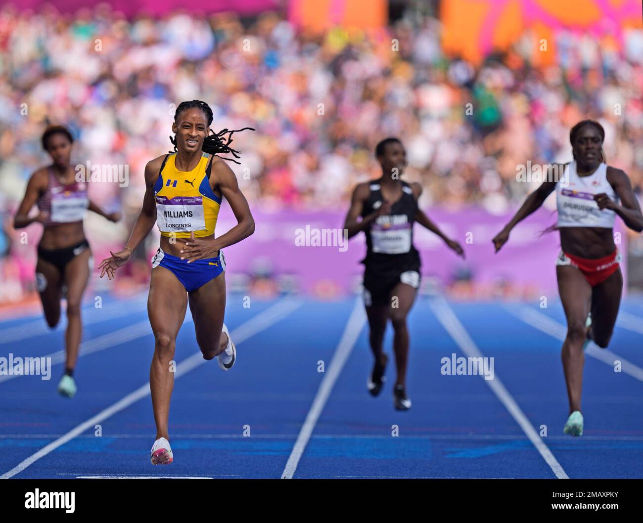 Sada Williams of Barbados, second left, crosses the finish line to win ...