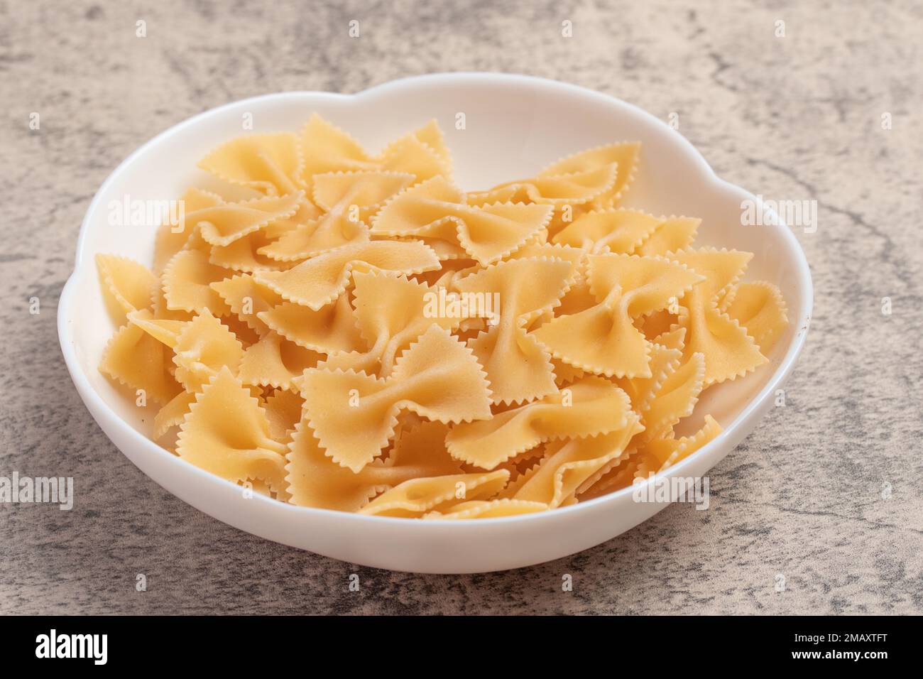 Raw macaroni in white cup on brown background Stock Photo - Alamy