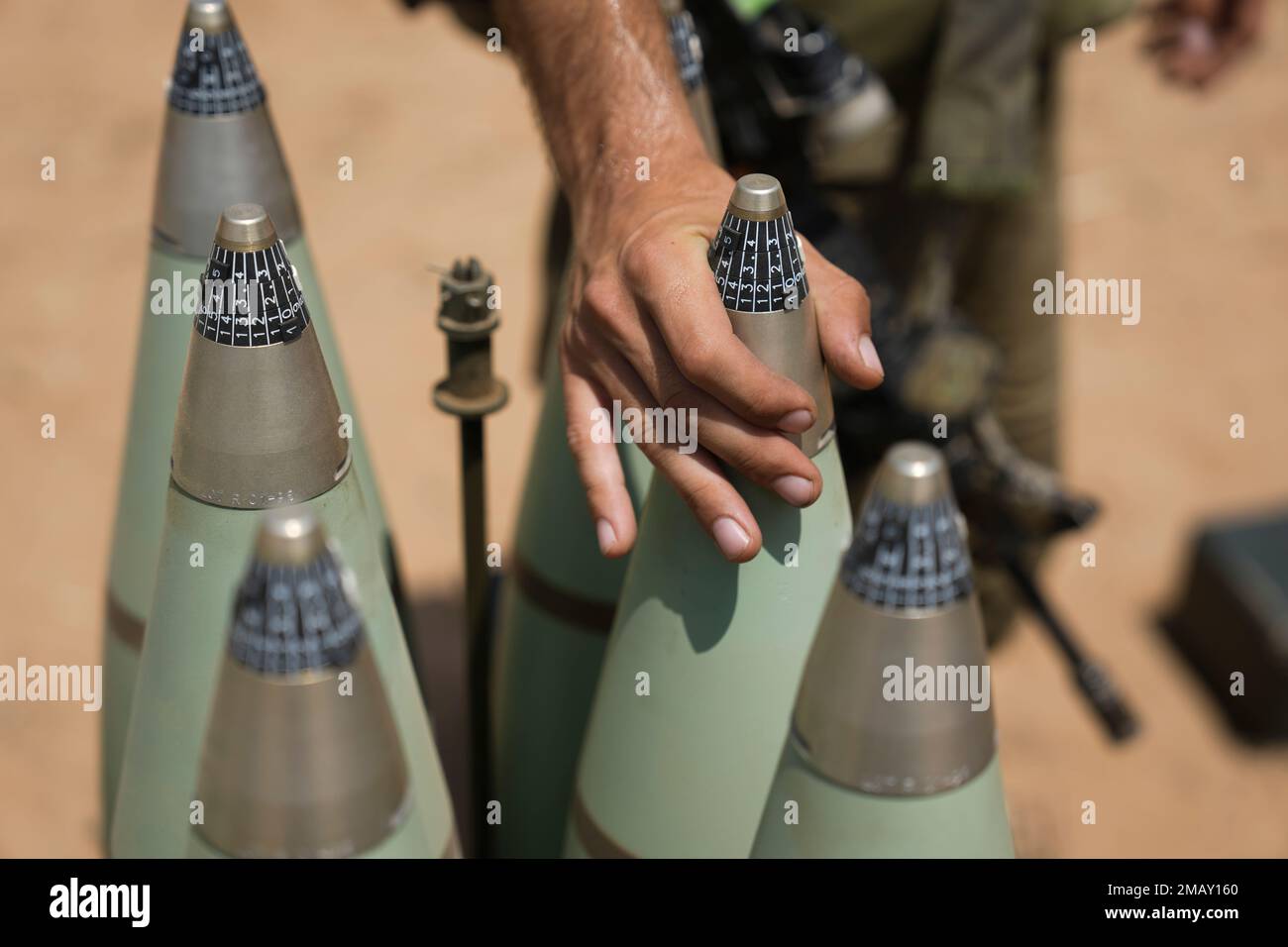 An Israeli soldier from the artillery unit loads a tank shell at the ...