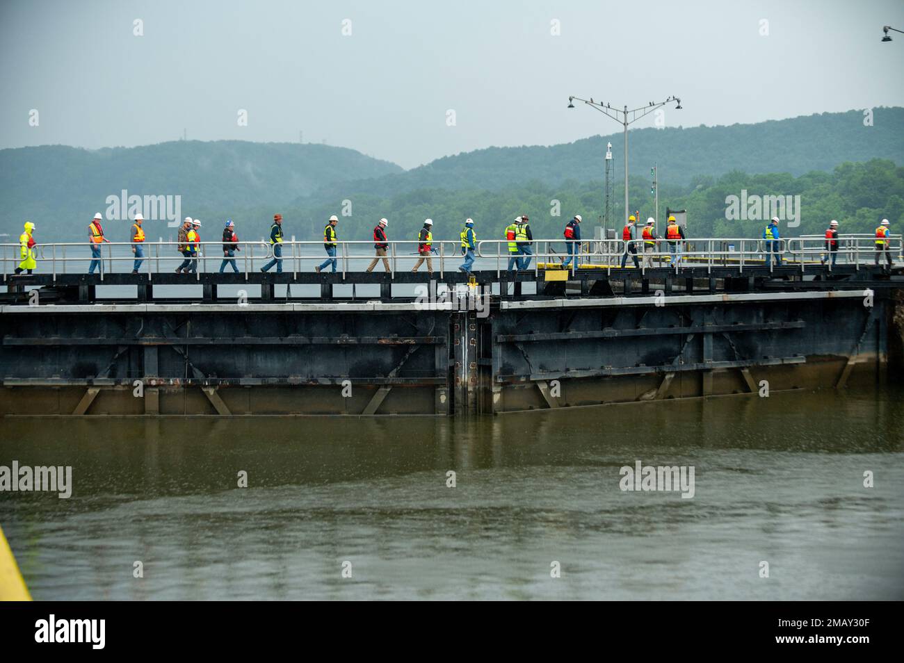 Construction professionals walk across the miter gate of the main ...