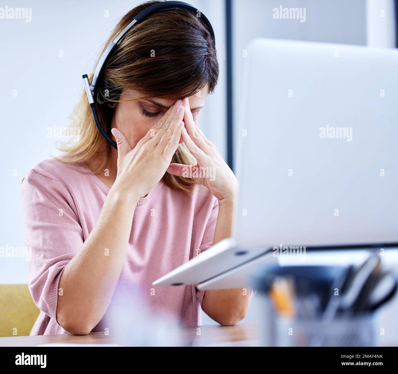 How am I going to fix this. a mature call centre agent looking stressed ...