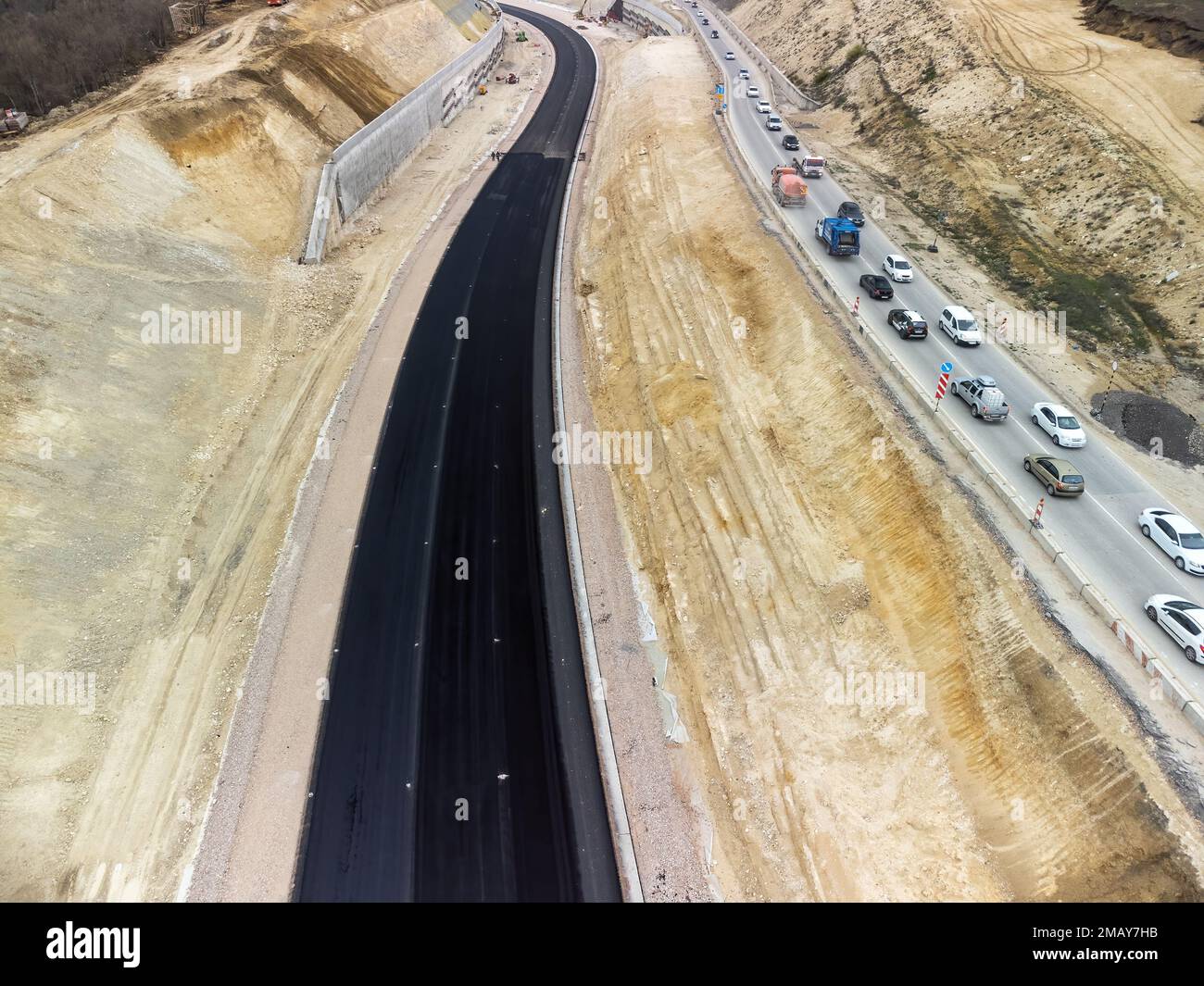 Mountain road constraction. Workers reinforce the slope over the new ...