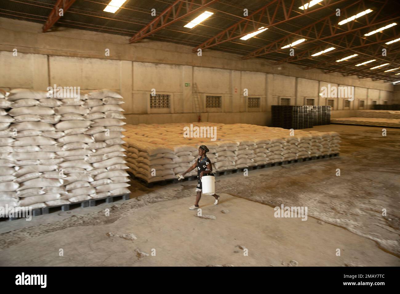 A worker walks past sacks of rice inside a World Food Program warehouse ...