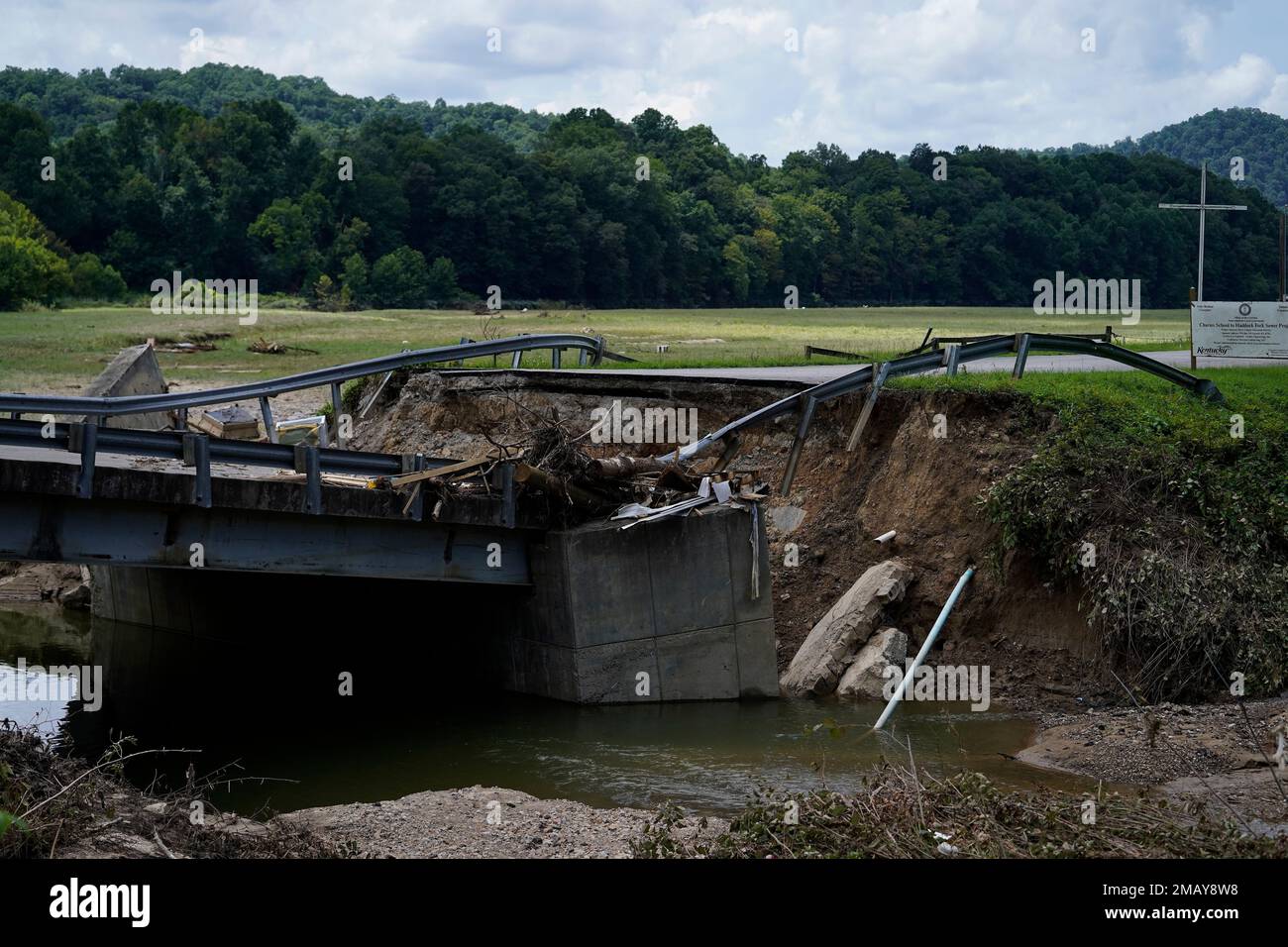 The road leading to a bridge above a creek cracks and breaks after ...