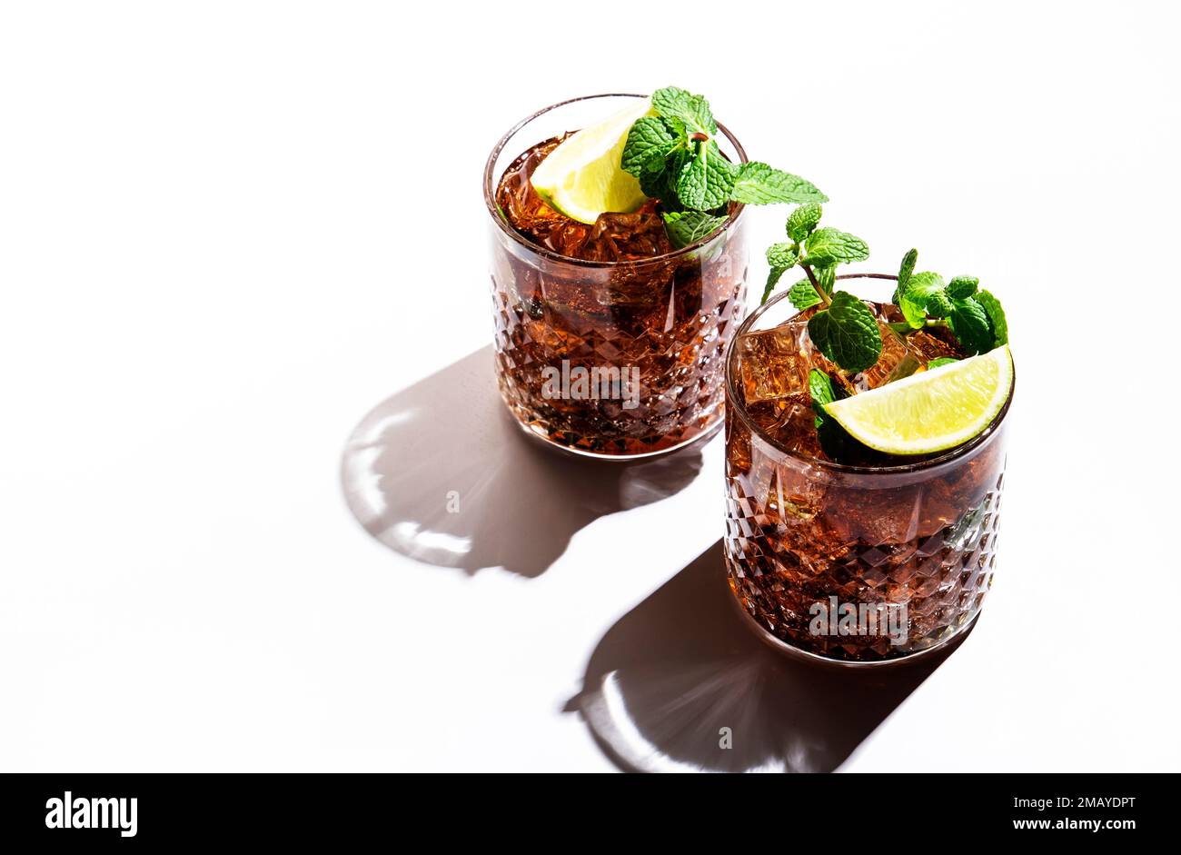 Rum cola cocktail with strong alcohol and ice, garnished with mint and ...