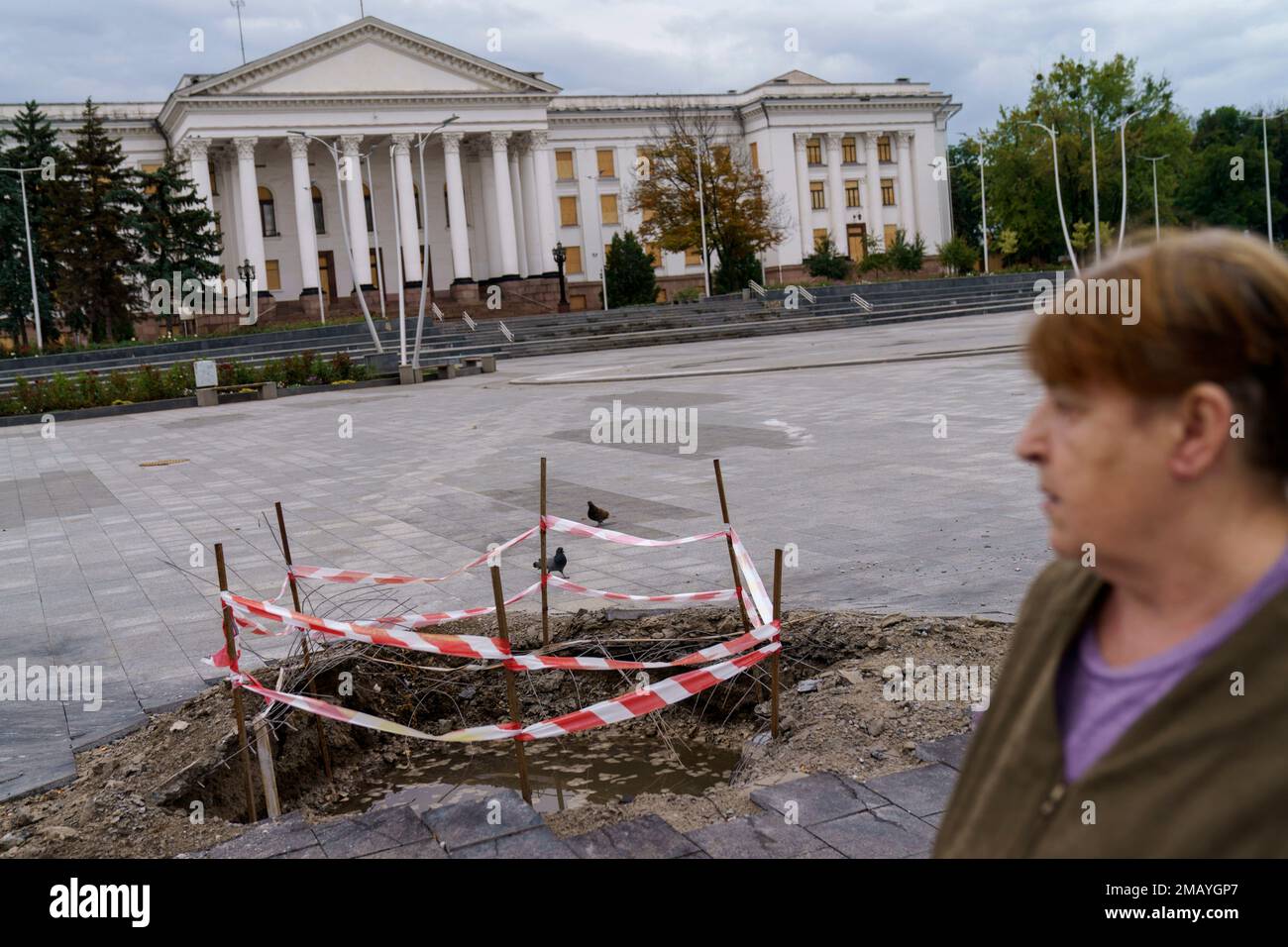 A crater from an earlier Russian shelling sits next to the shuttered ...