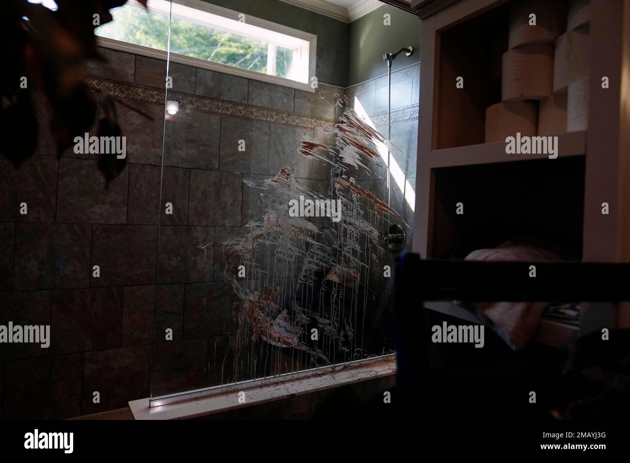 Mud is smeared on a glass shower door in the aftermath of massive ...