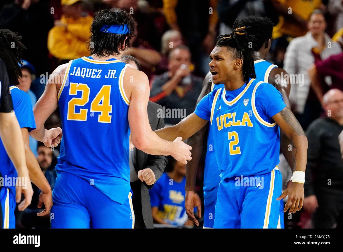 UCLA's Jamie Jaquez Jr. (24) is greeted by Dylan Andrews (2) after hitting a 3-pointer against ...