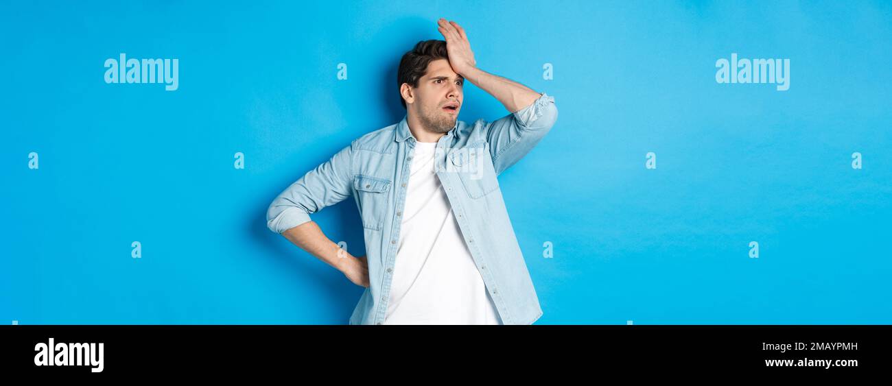 Upset man making facepalm and looking away concerned, forgot something ...