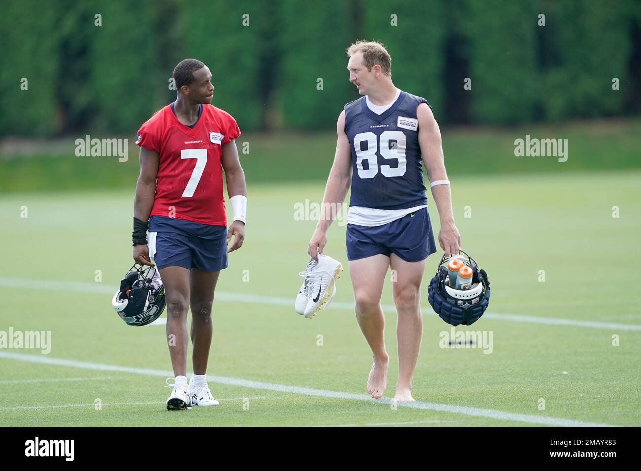 Seattle Seahawks quarterback Geno Smith, left, walks with tight end ...