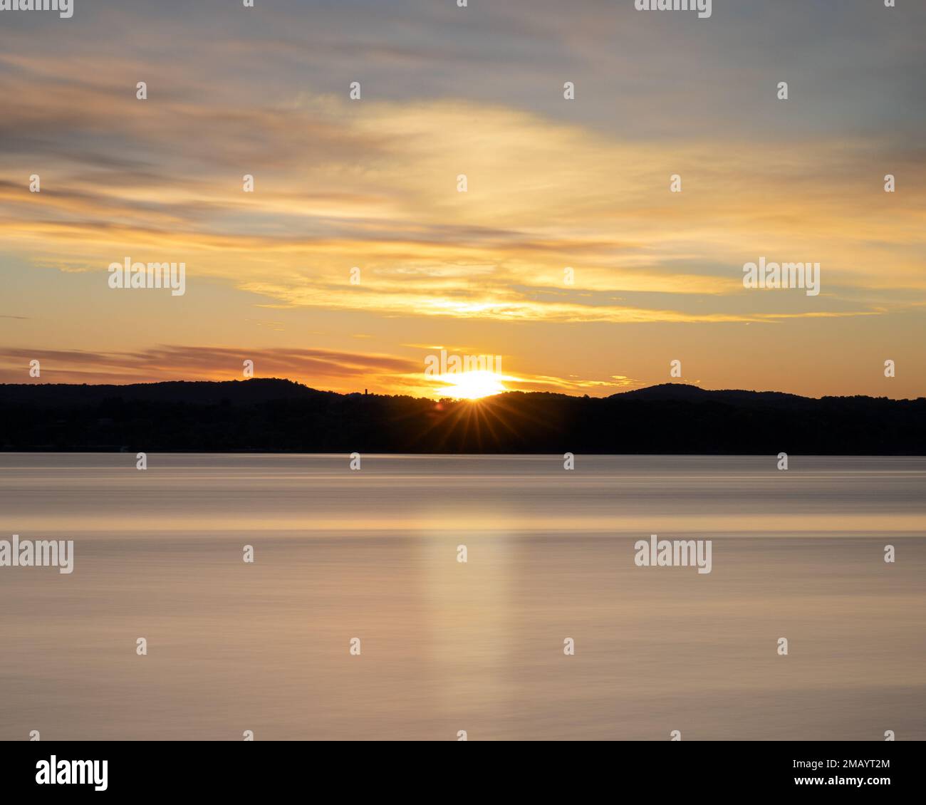 The glowing sunbeams of the sun coming up from behind the skyline of ...
