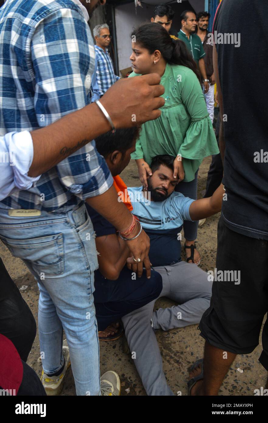 A relative faints as rescuers pull out bodies of victims after a fire ...