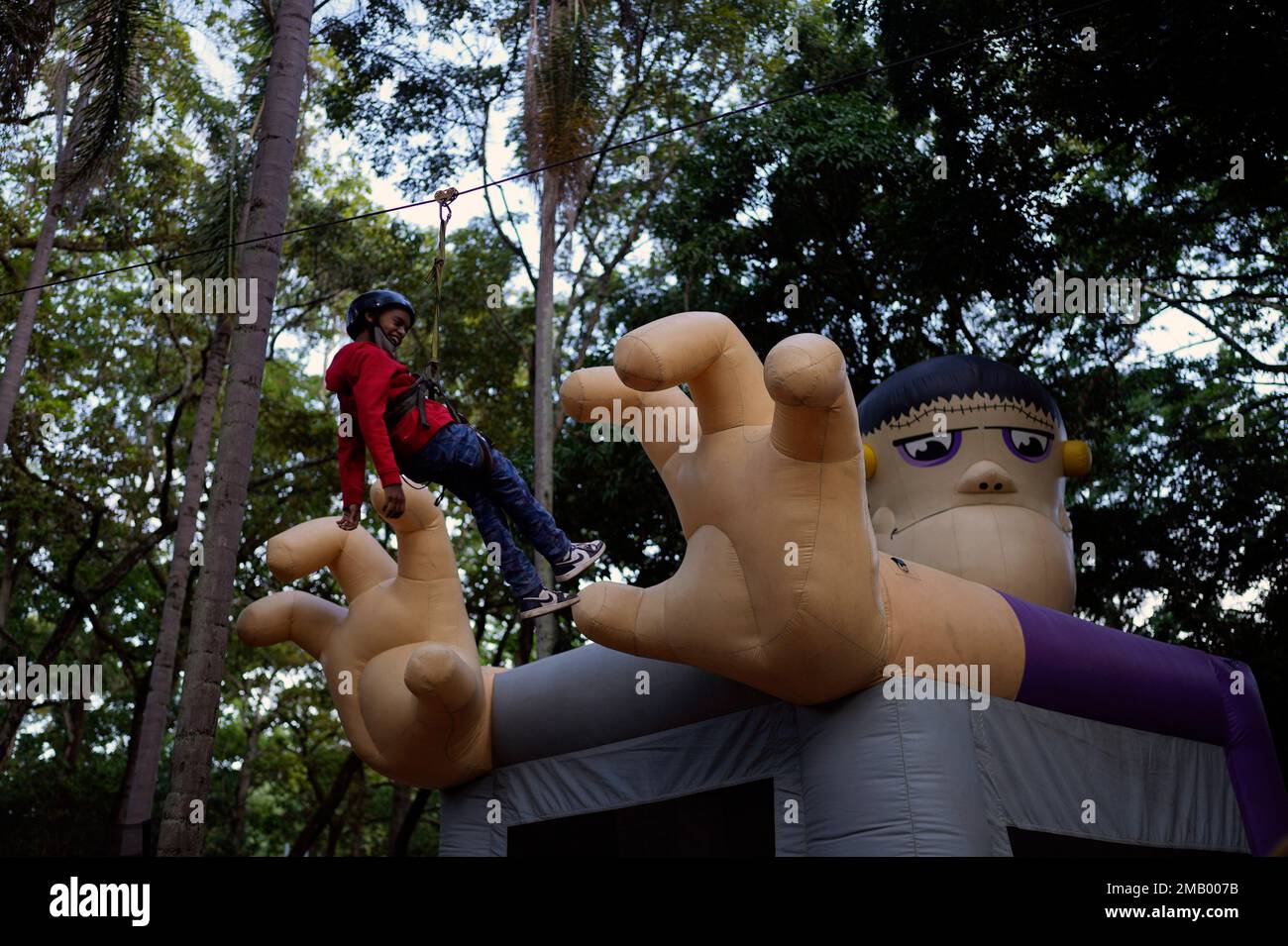 A boy slips on a pulley set in the park Los Caobos during an event to ...