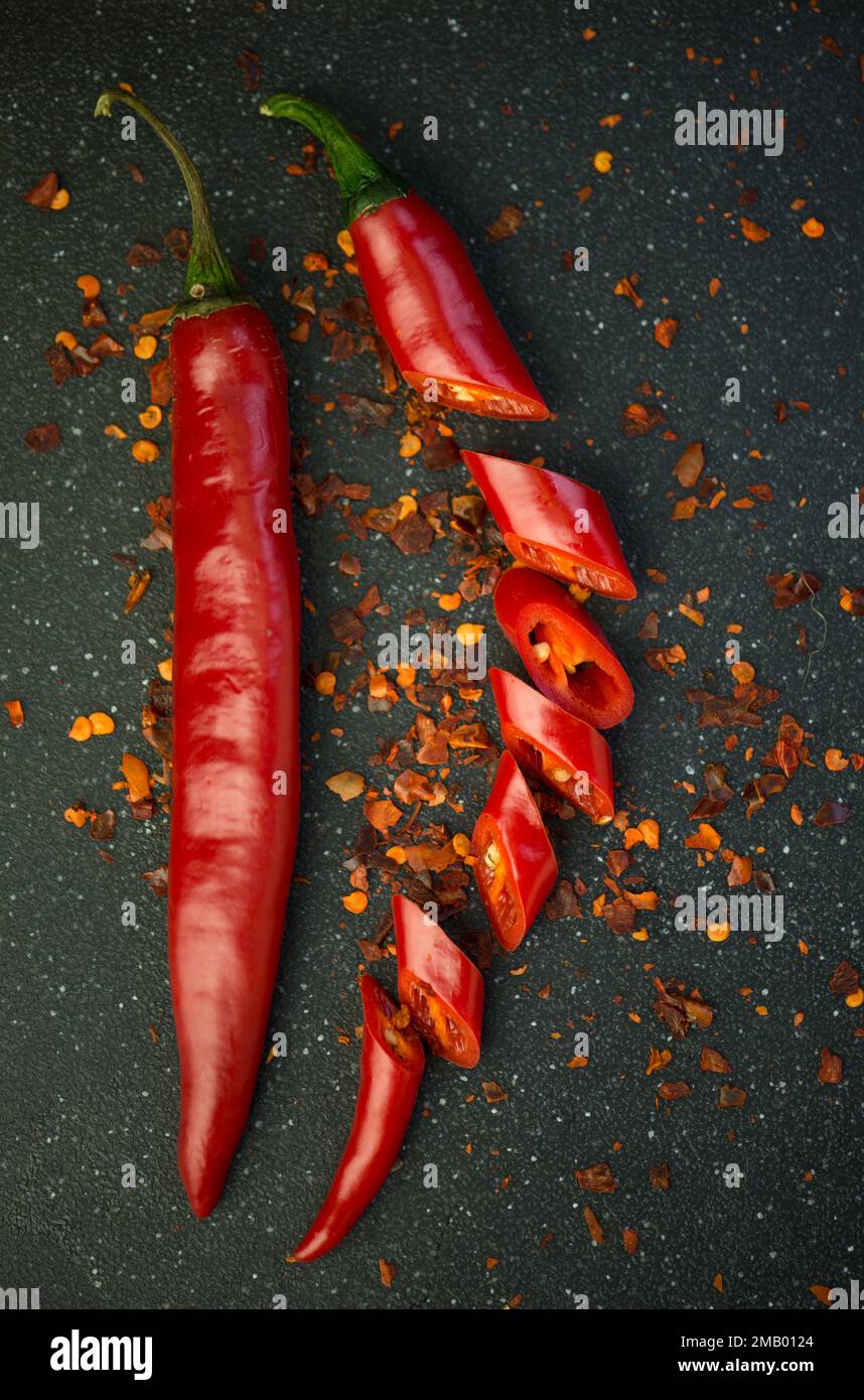 Red chili pepper cut into pieces on a black background. Hot spice, red ...