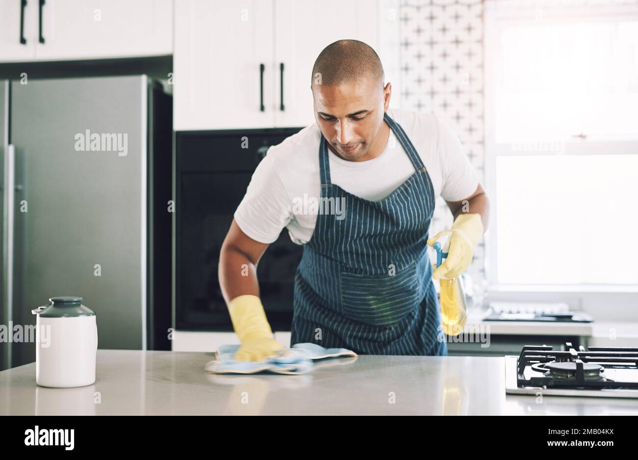 Cant miss a spot. a young man wiping a surface at home Stock Photo - Alamy