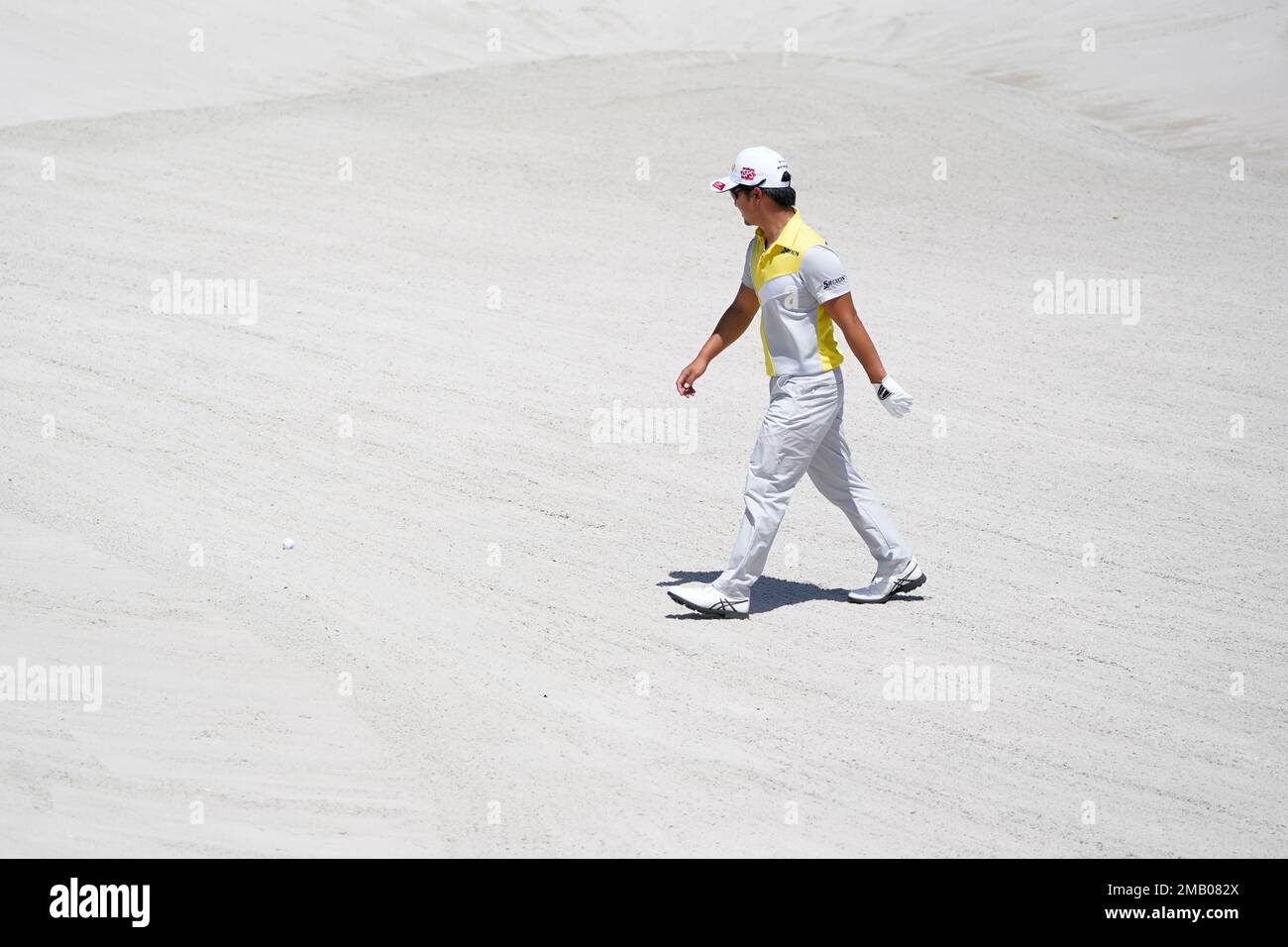 Jinichiro Kozuma, of Japan, looks at his ball in a trap on the first ...
