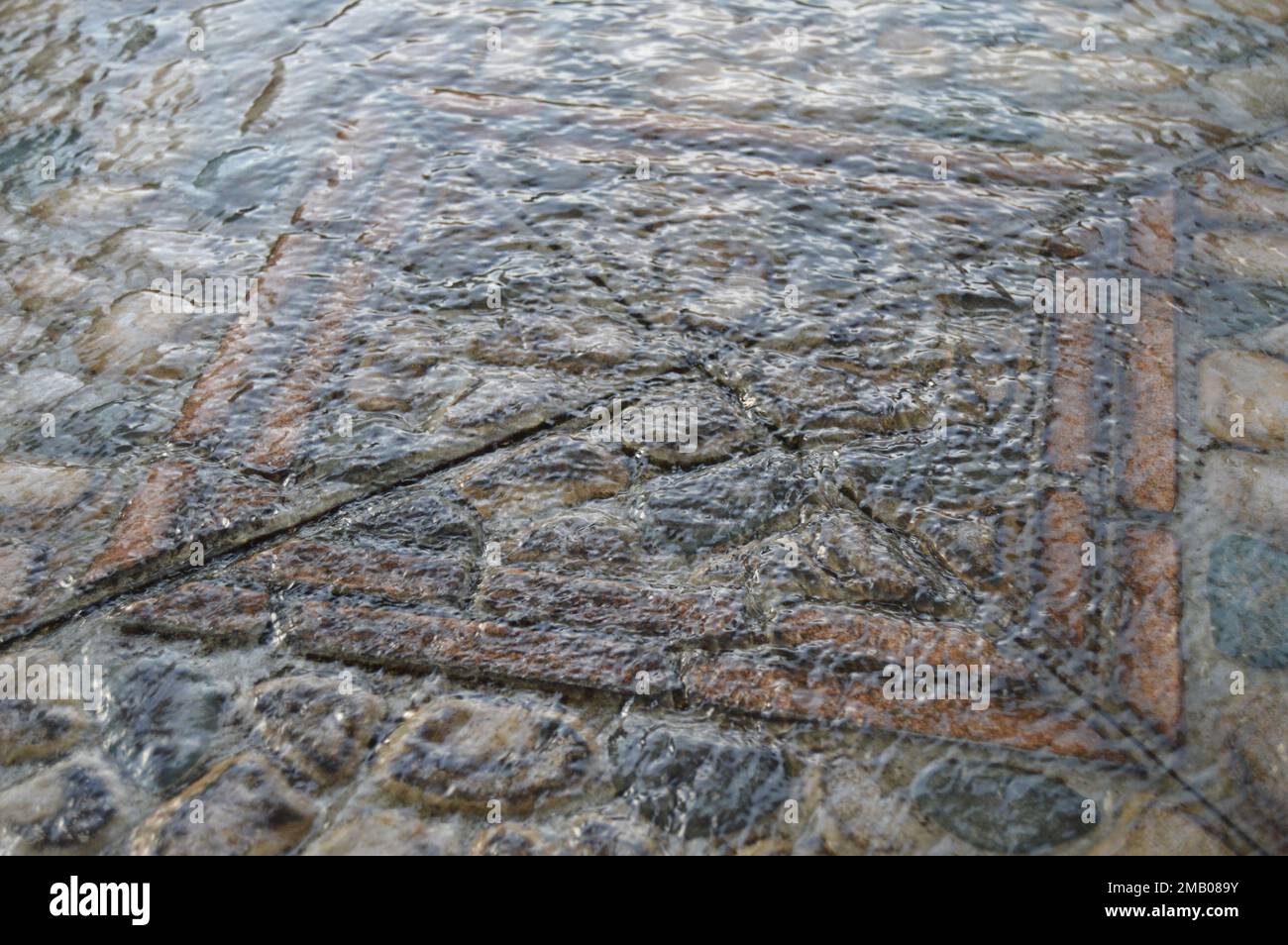 Portrait of water ripples on the floor of the yard that has a rocky ...