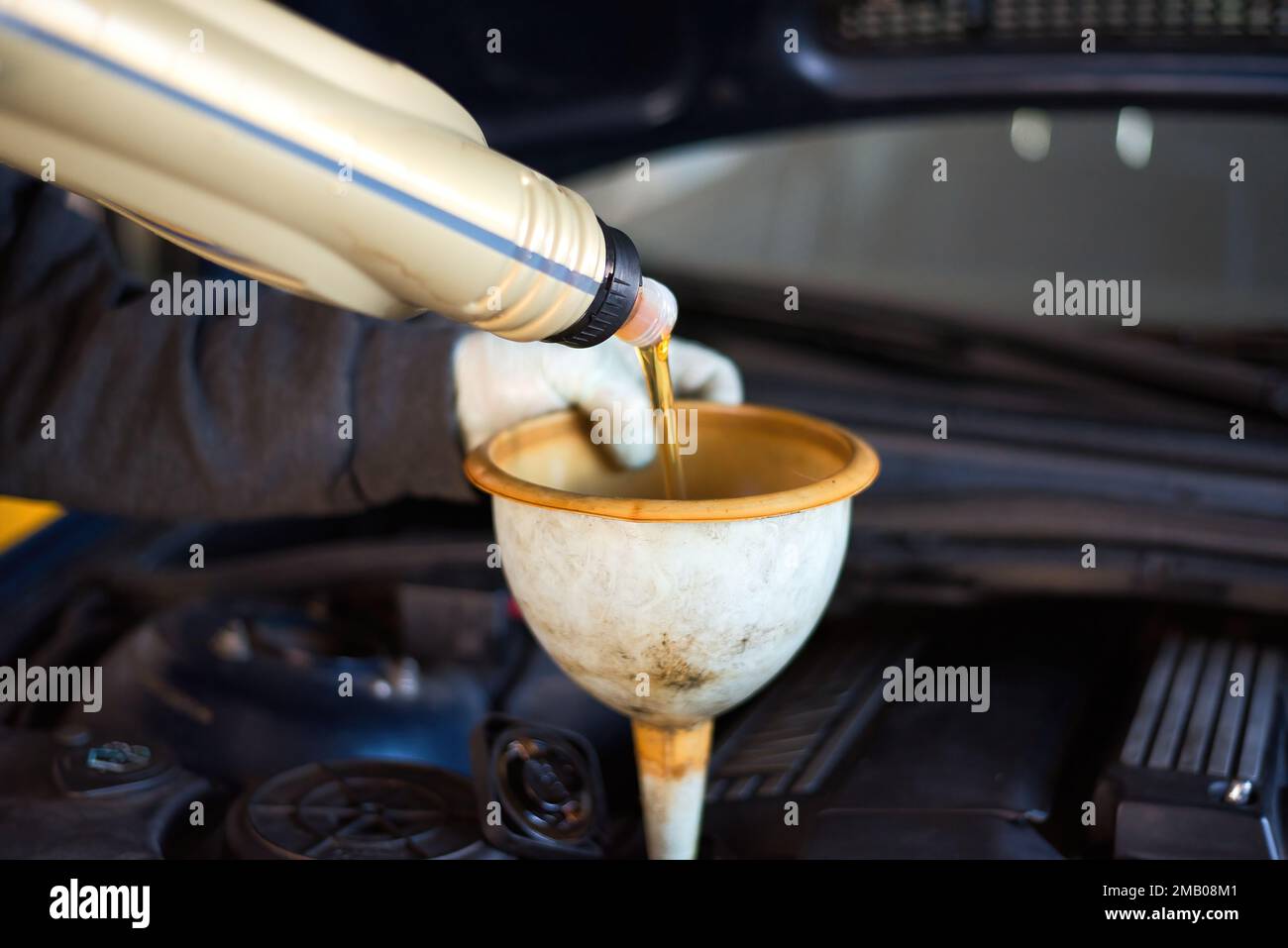 work in a garage , worker controls and changes the motoroil , car ...