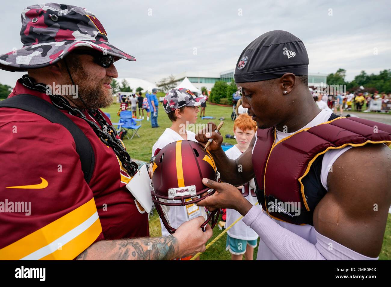 Washington Commanders wide receiver Terry McLaurin, right, signs an ...