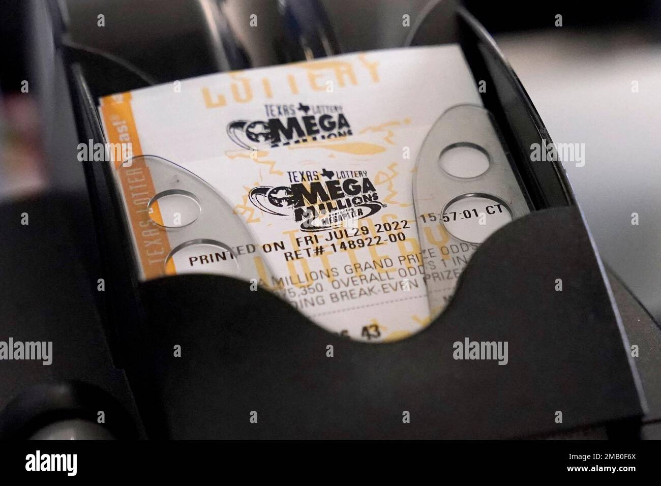 A purchased Mega Millions ticket sits in a dispenser at a convenience ...