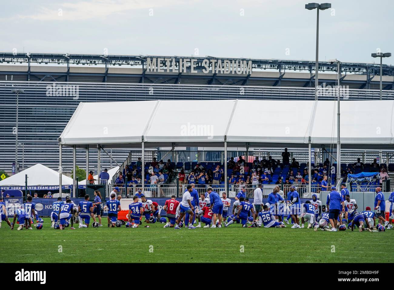 The New York Giants stretch out as spectators watch during training ...