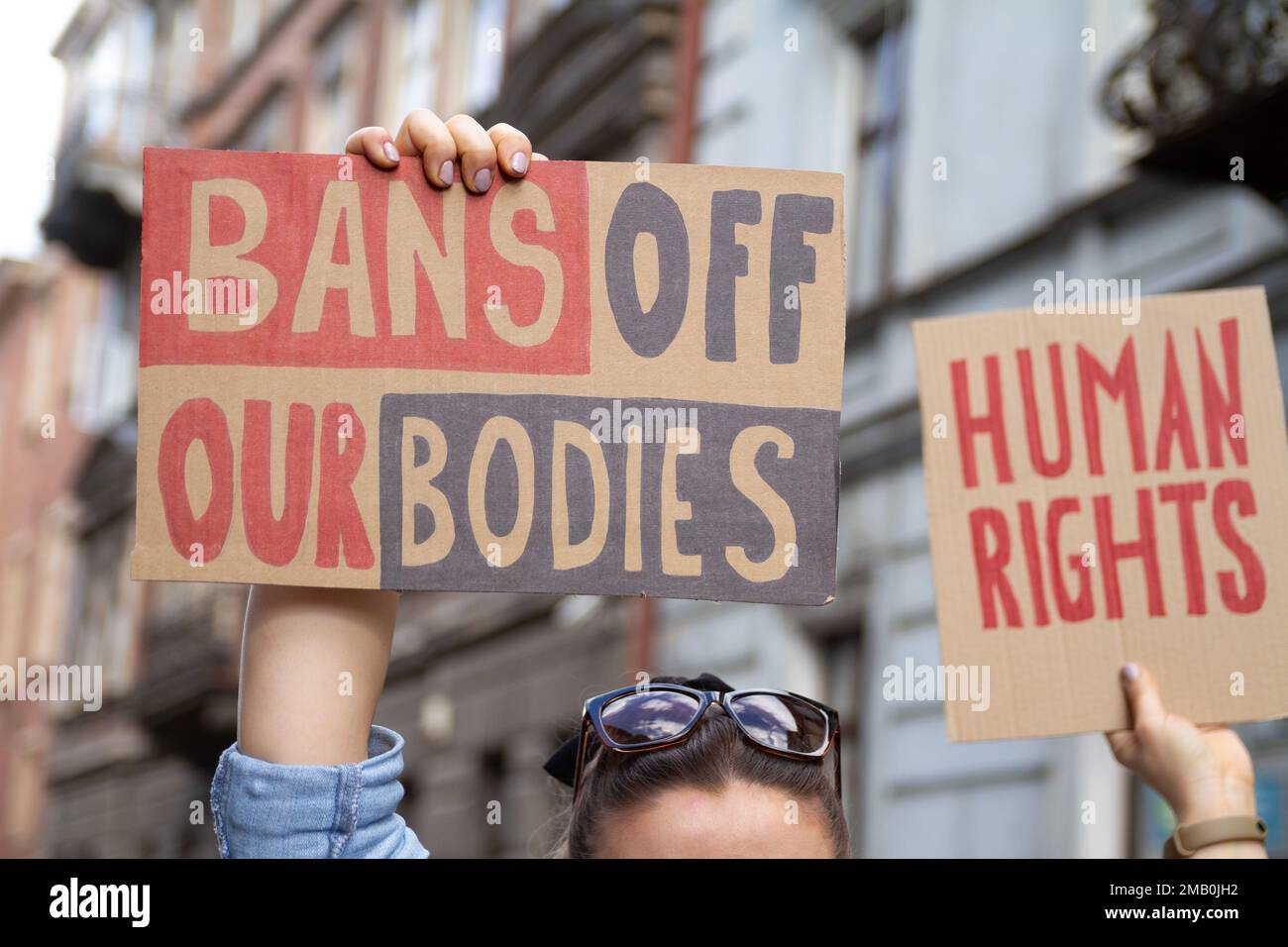 Protesters holding signs Bans Off Our Bodies and Human rights. People ...
