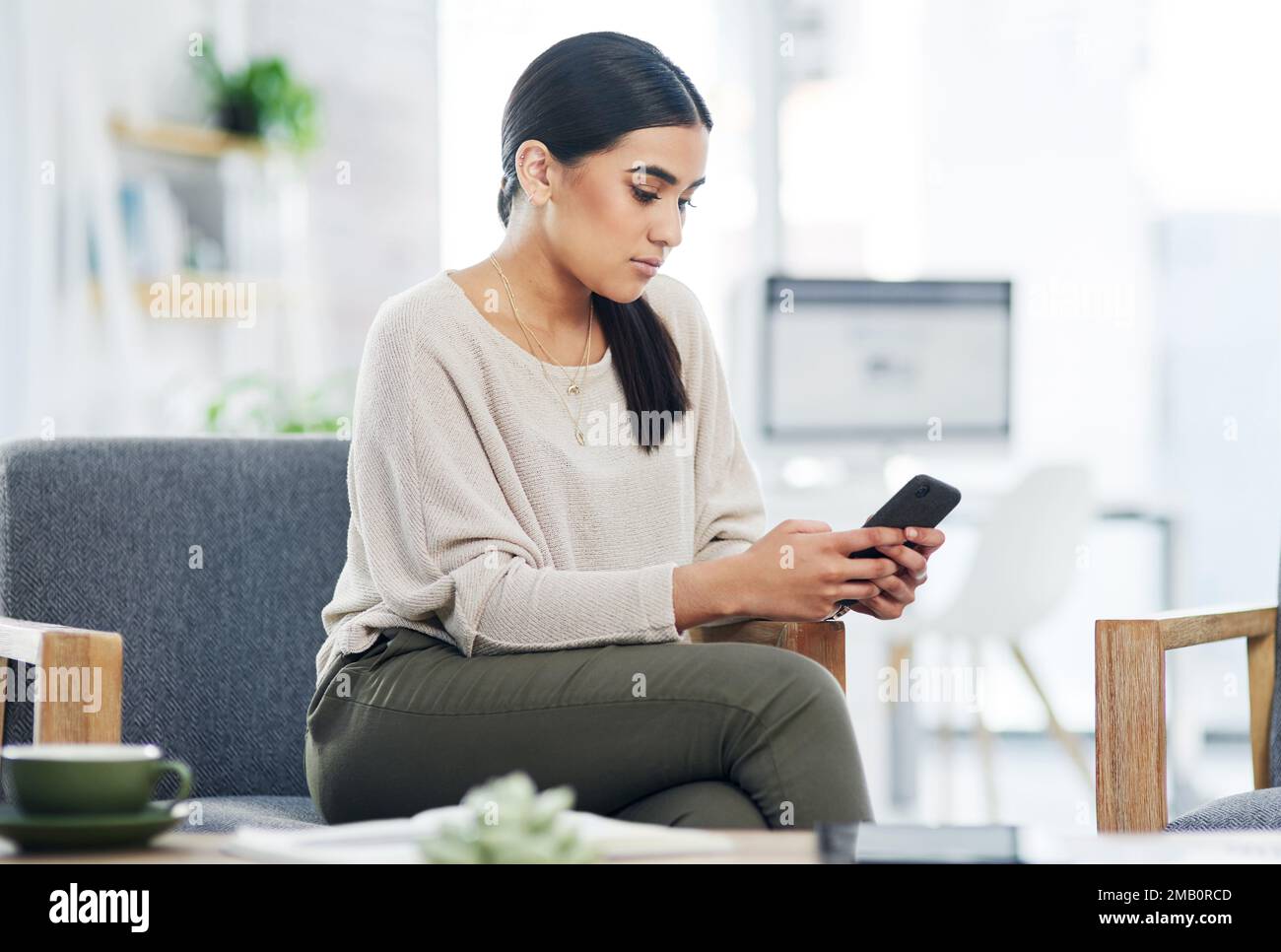 Staying in touch with her network. a young businesswoman using a ...