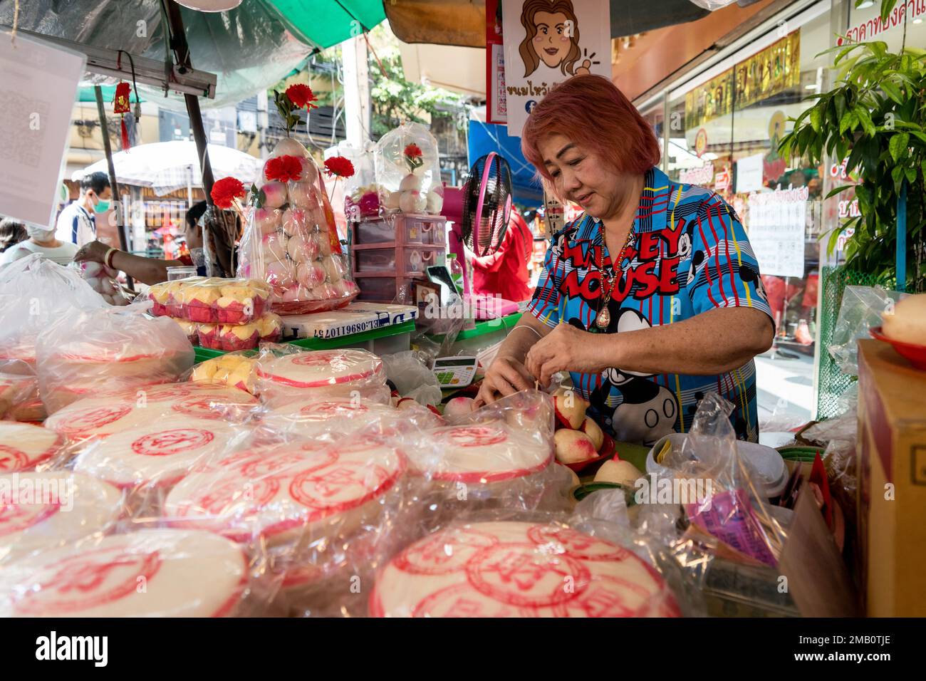 A traditional Chinese steamed cake vendor prepares her product for an ...