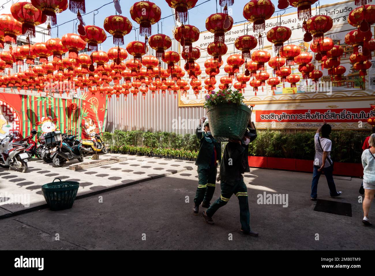 Workers carry fresh baskets of fresh flowers into a temple in Chinatown ...
