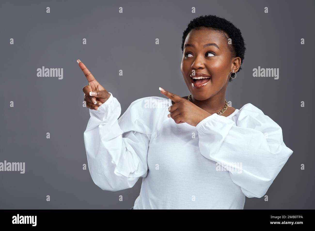 You saw it here first. a young woman pointing at copy-space while ...