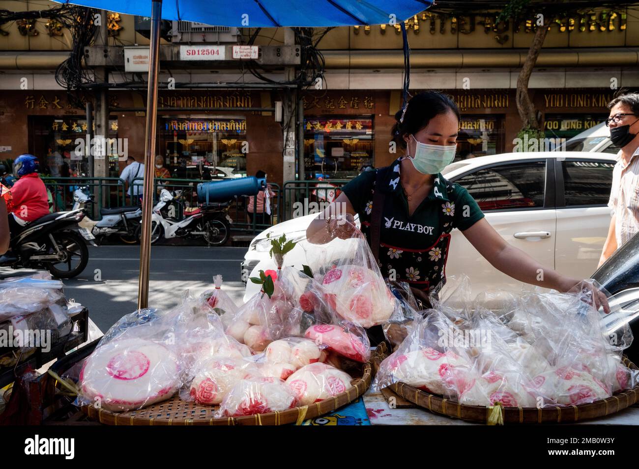 A traditional Chinese steamed cake vendor prepares her product for an ...