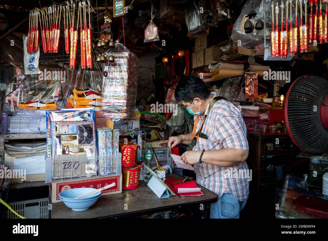 A firecracker vendor paints ang pao envelopes at their shop in ...