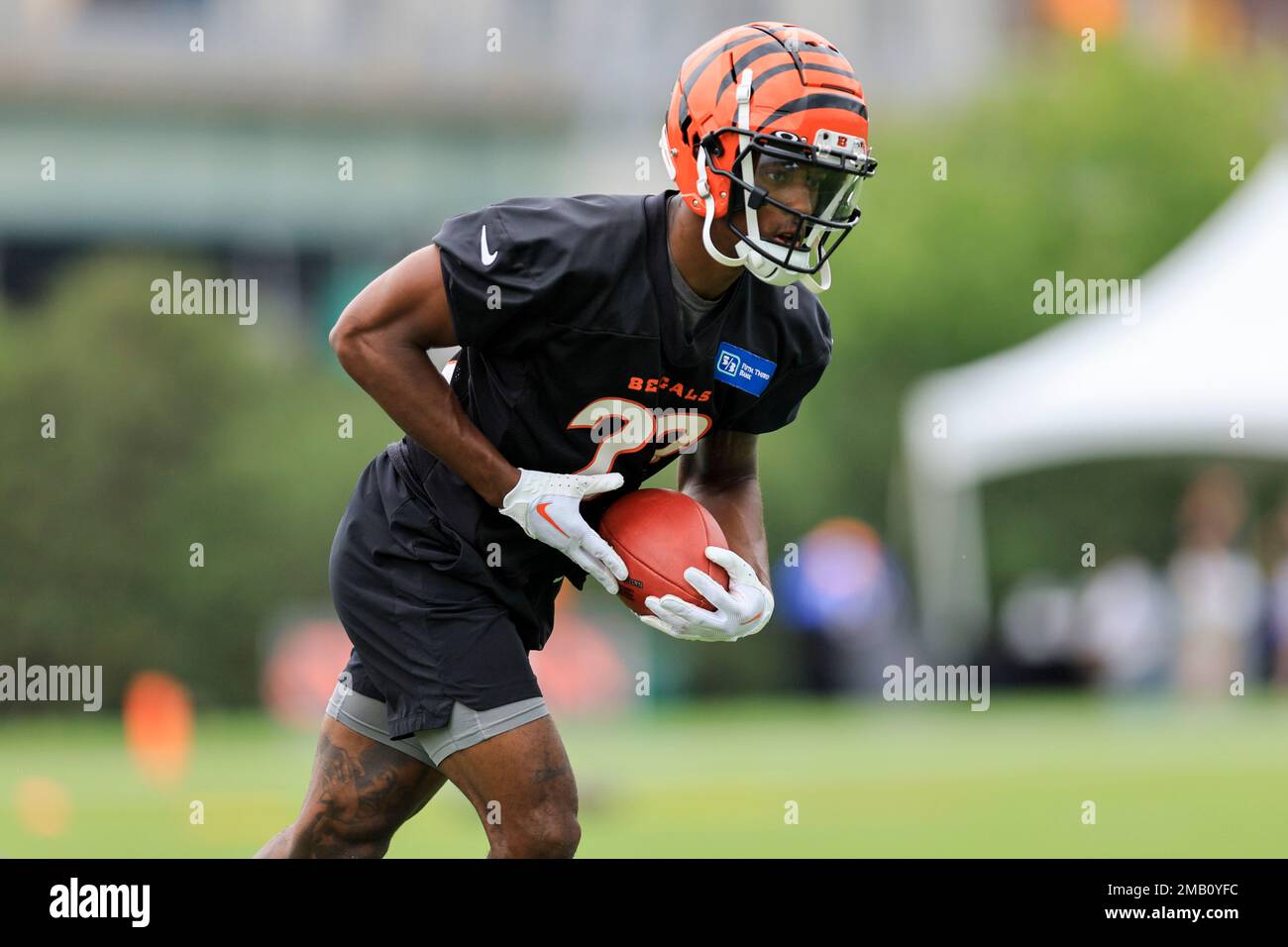 Cincinnati Bengals' Dax Hill carries the ball in a drill during a ...