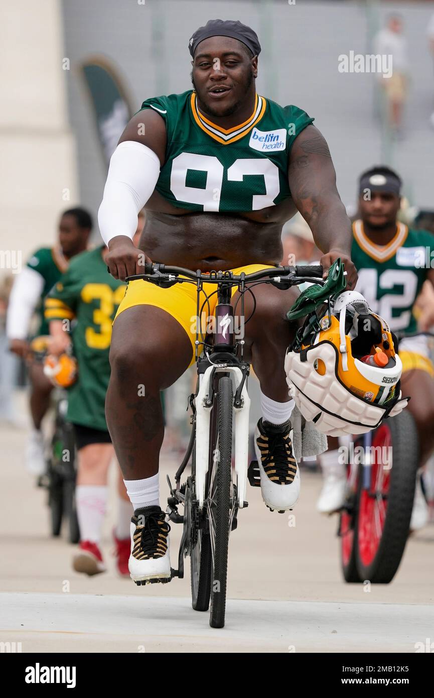 Green Bay Packers' T.J. Slaton rides a bike to the NFL football team's ...
