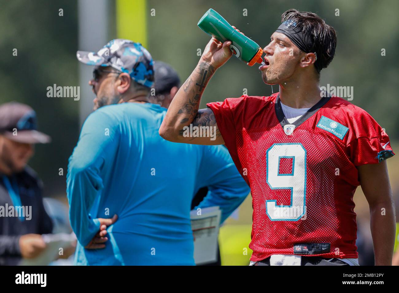 Carolina Panthers quarterback Matt Corral has a drink during a break at ...