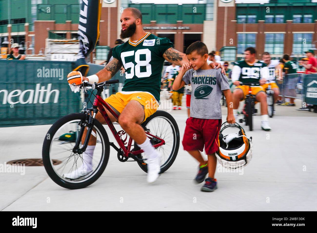 Green Bay Packers' Isaiah McDuffie rides a bike to the NFL football ...