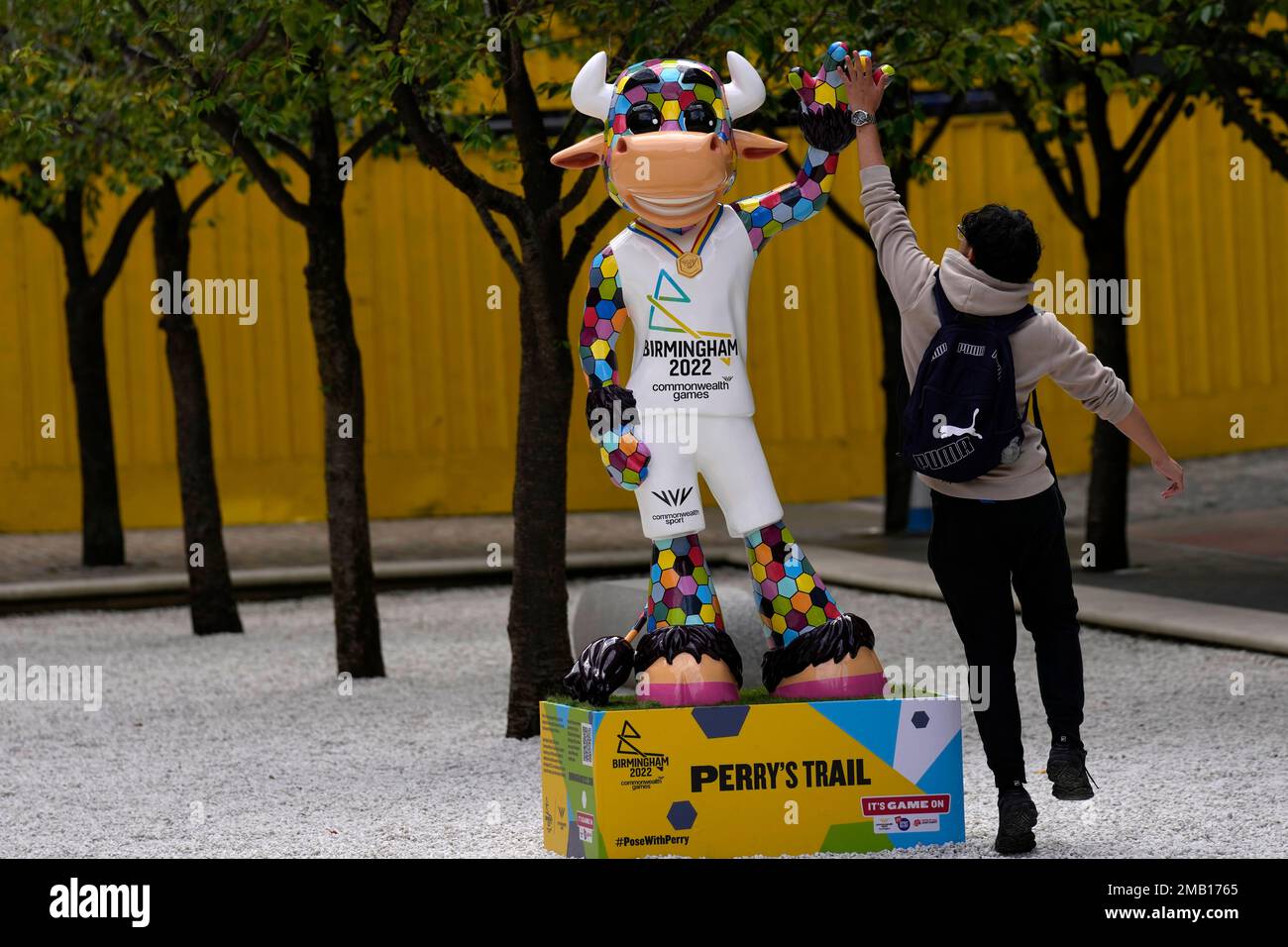 A boy jumps to give a high five to the Commonwealth Games mascot, Perry ...
