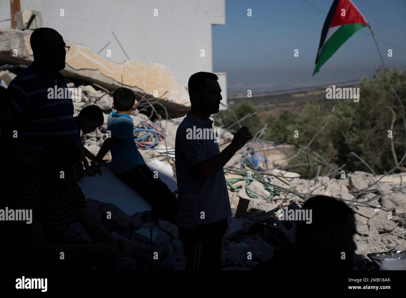 Palestinians gather on top of the rubble of the family house of Youssef ...