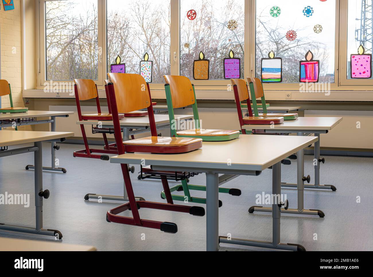 Red chair in a classroom stands on a table against a blurred background ...