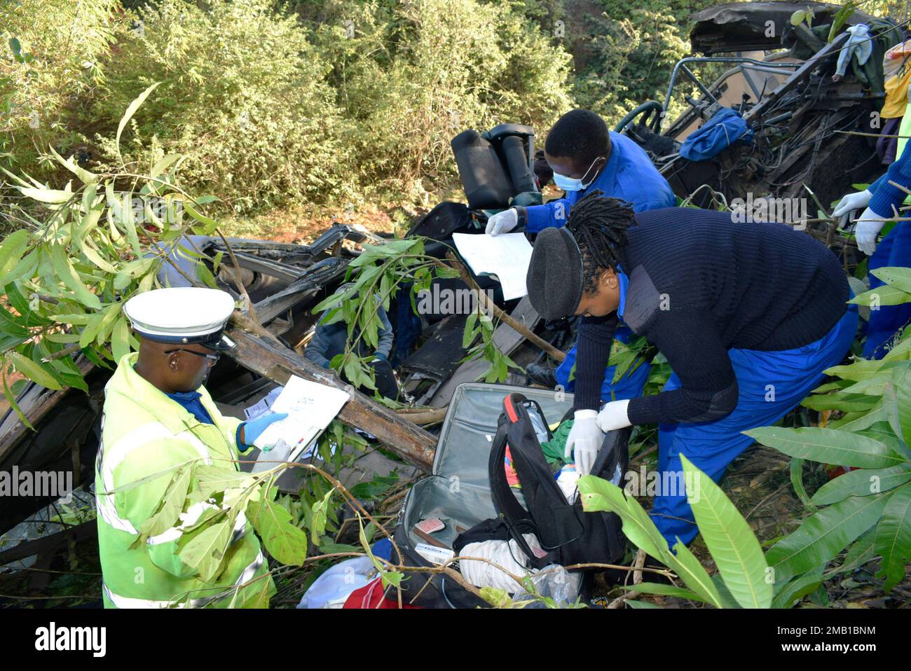 Kenyan police officers collect items from the wreckage of a bus that ...
