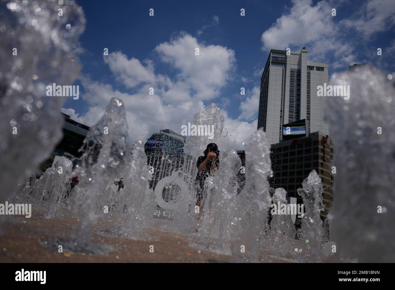 Children cool themselves off by playing in a fountain in downtown Seoul ...